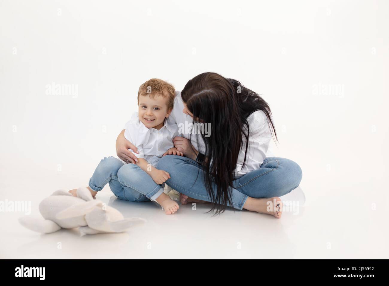Studio shot of two people, woman and boy having fun and cuddling ...