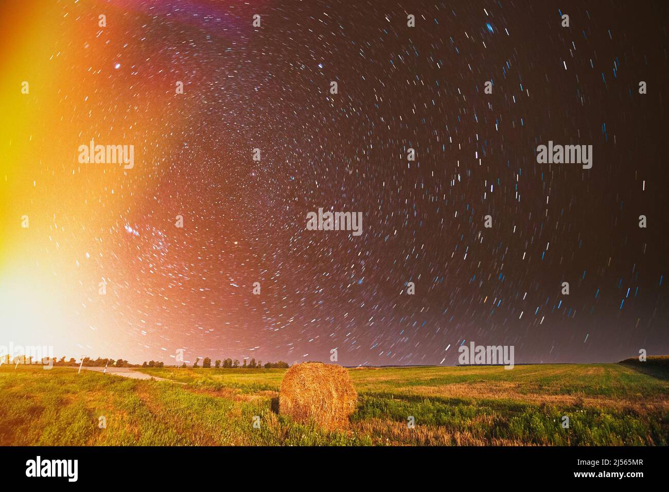 Night Starry Sky in rotation Above Country Field Meadow With Hay Bale ...
