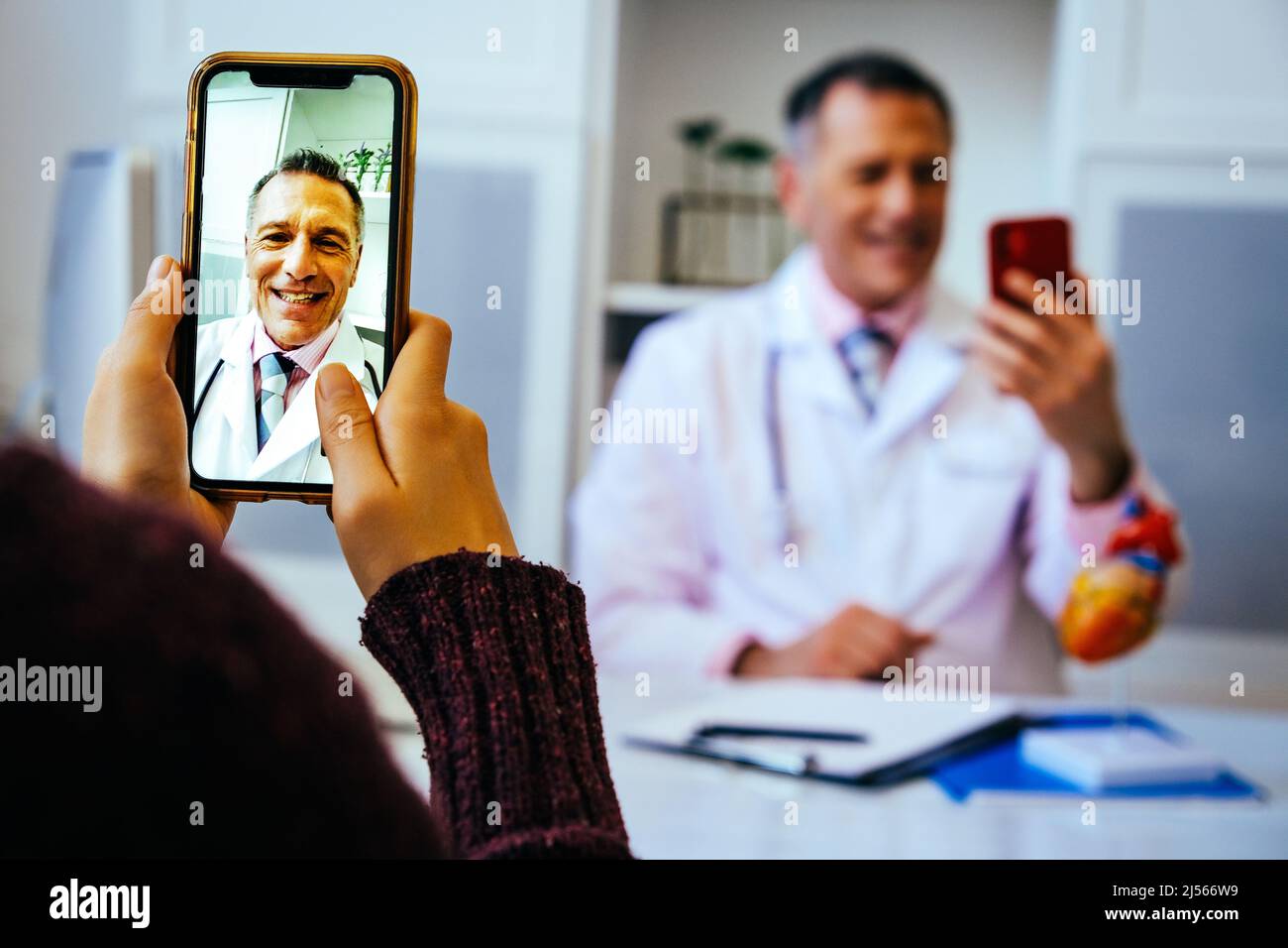 doctor and patient discussing something using smartphones in hospital ...