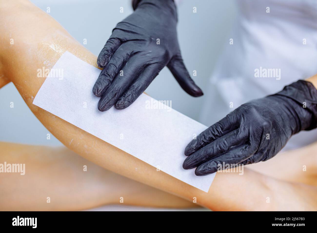 Sugaring: woman at cosmetics salon waxing legs Stock Photo - Alamy