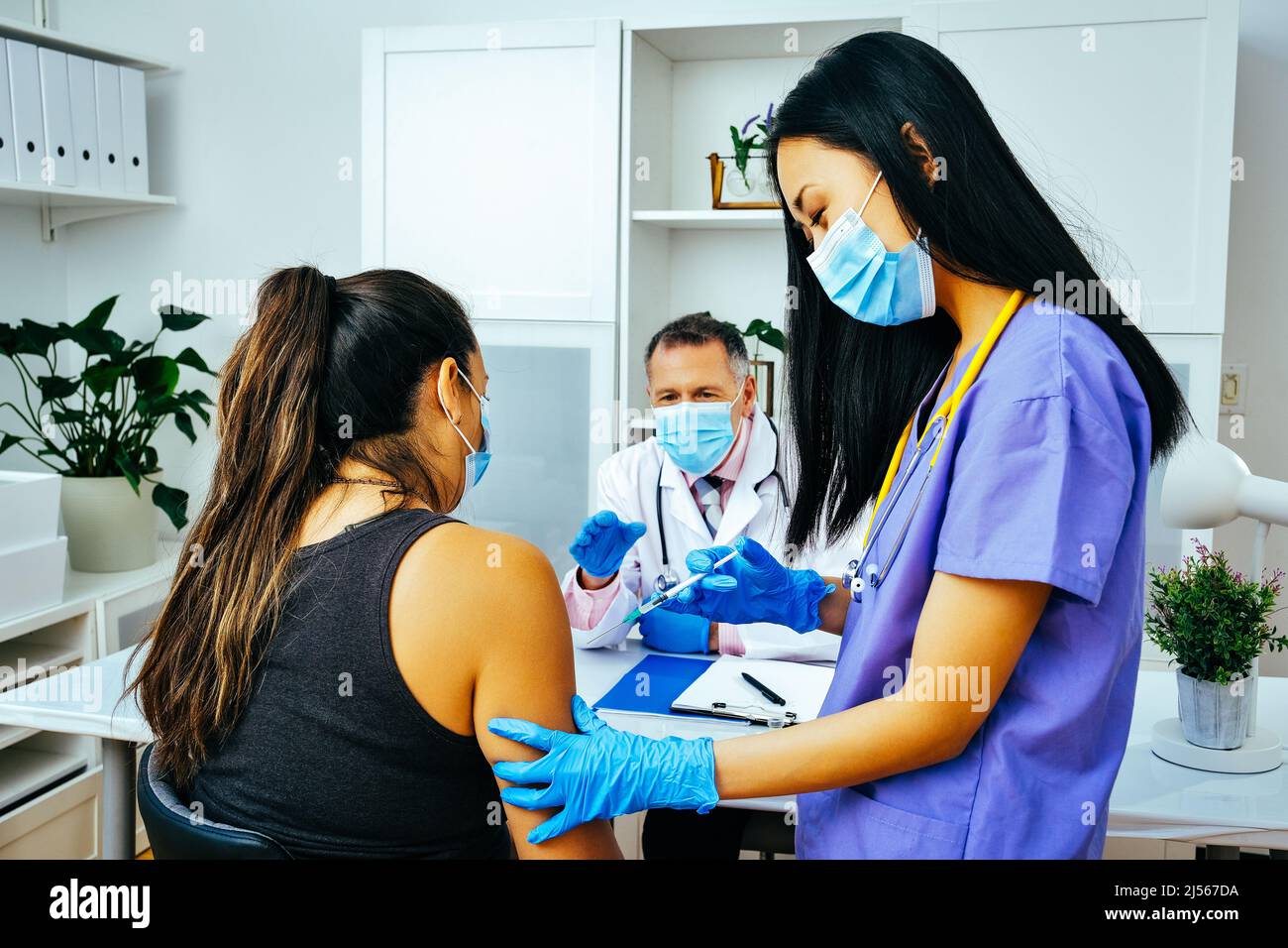 nurse making injection to female patient in doctor's office healthcare ...
