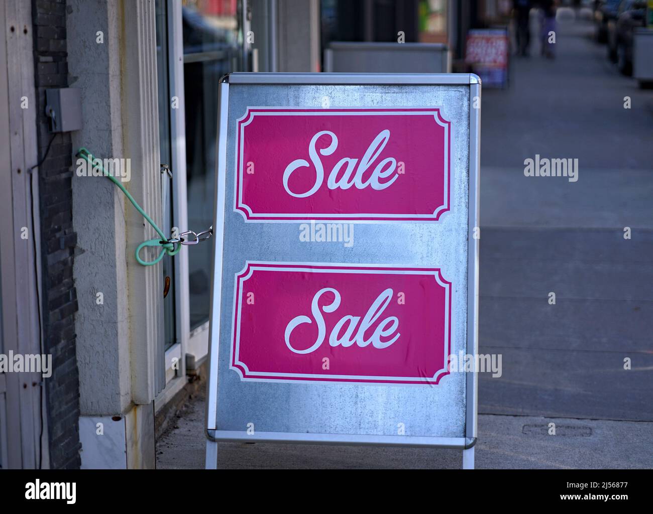 Advertising a sale on a sandwich board sign on the sidewalk in front of ...