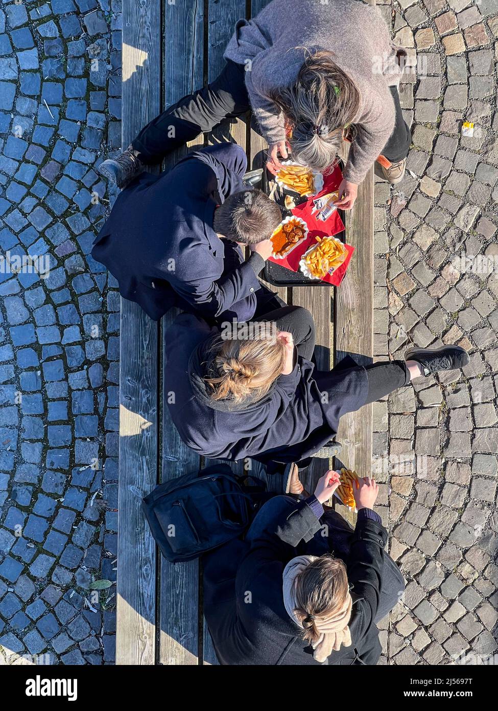 People eating chips on a bench, currywurst, snacking outside Stock ...