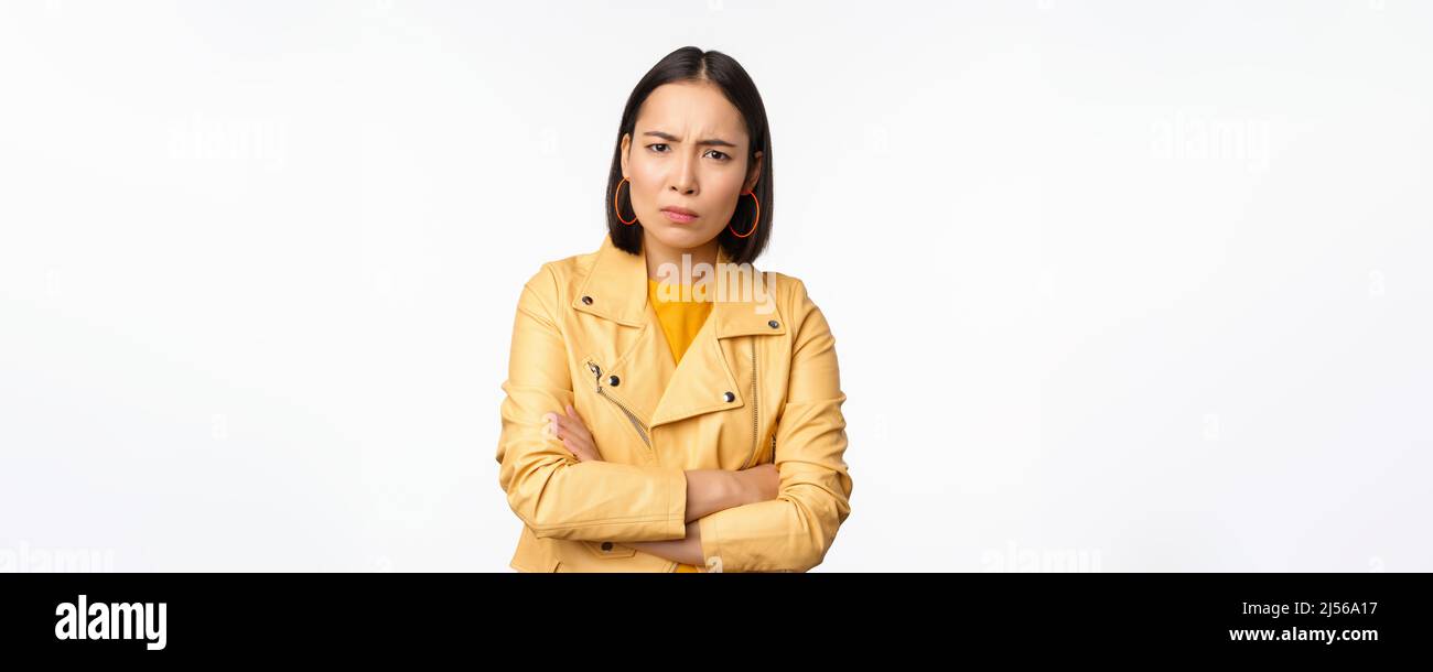 Image of asian girl looking angry and hurt, staring with upset ...