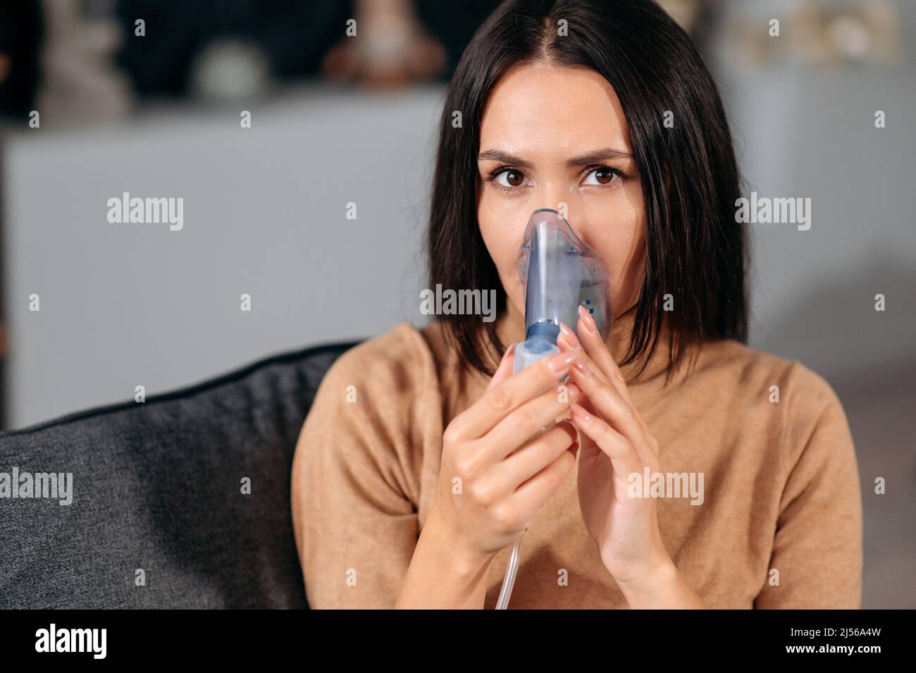 Close-up photo of sick caucasian young woman with an inhaler. Unhealthy ...