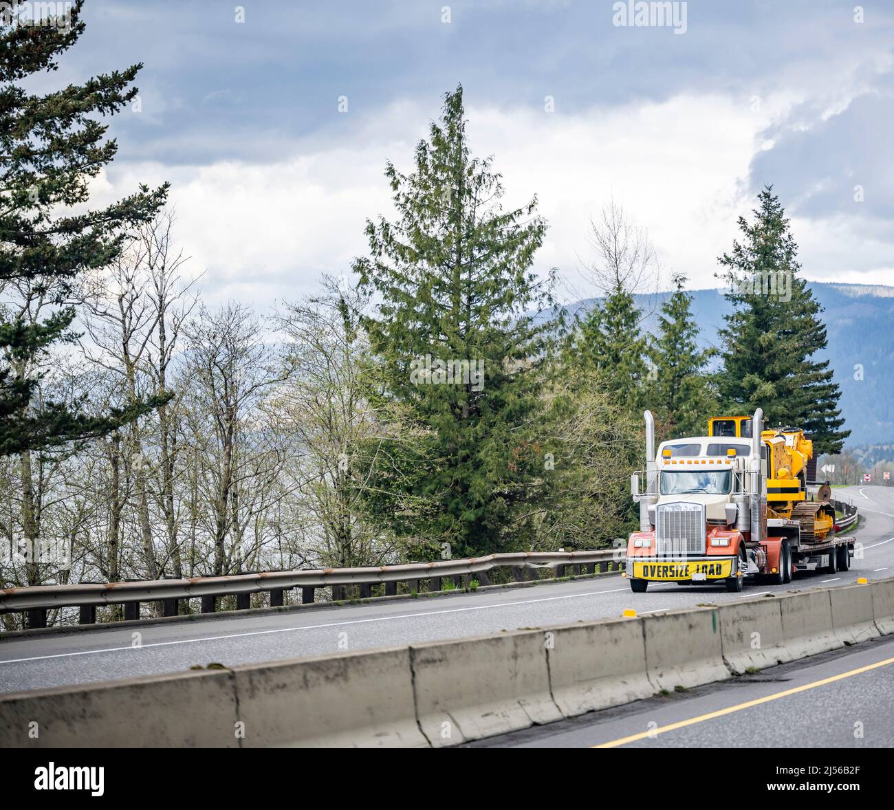 Classic orange big rig semi truck with oversize load sign on the bumper ...