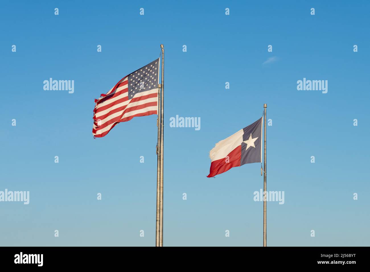 The Texas state flag flies beside the U.S. flag, the Stars and Stripes ...