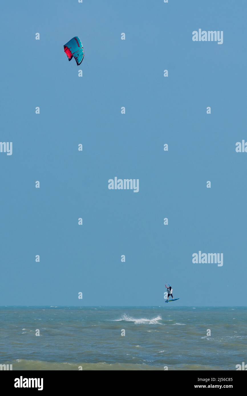 A kite surfer jumps out of the water while kiting in the Gulf of Mexico ...