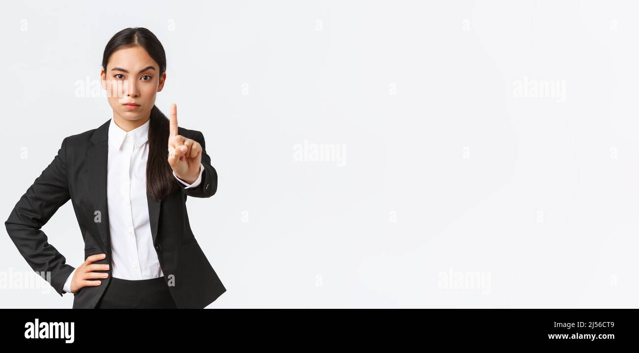 Serious angry asian businesswoman making restriction, give warning sign ...