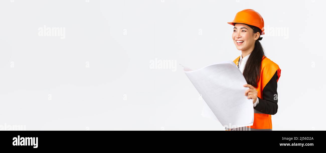 Satisfied happy asian female chief engineer looking at results of ...
