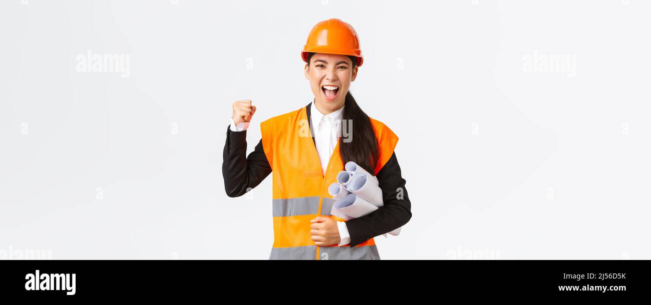 Successful female asian engineer, architect in safety helmet and ...