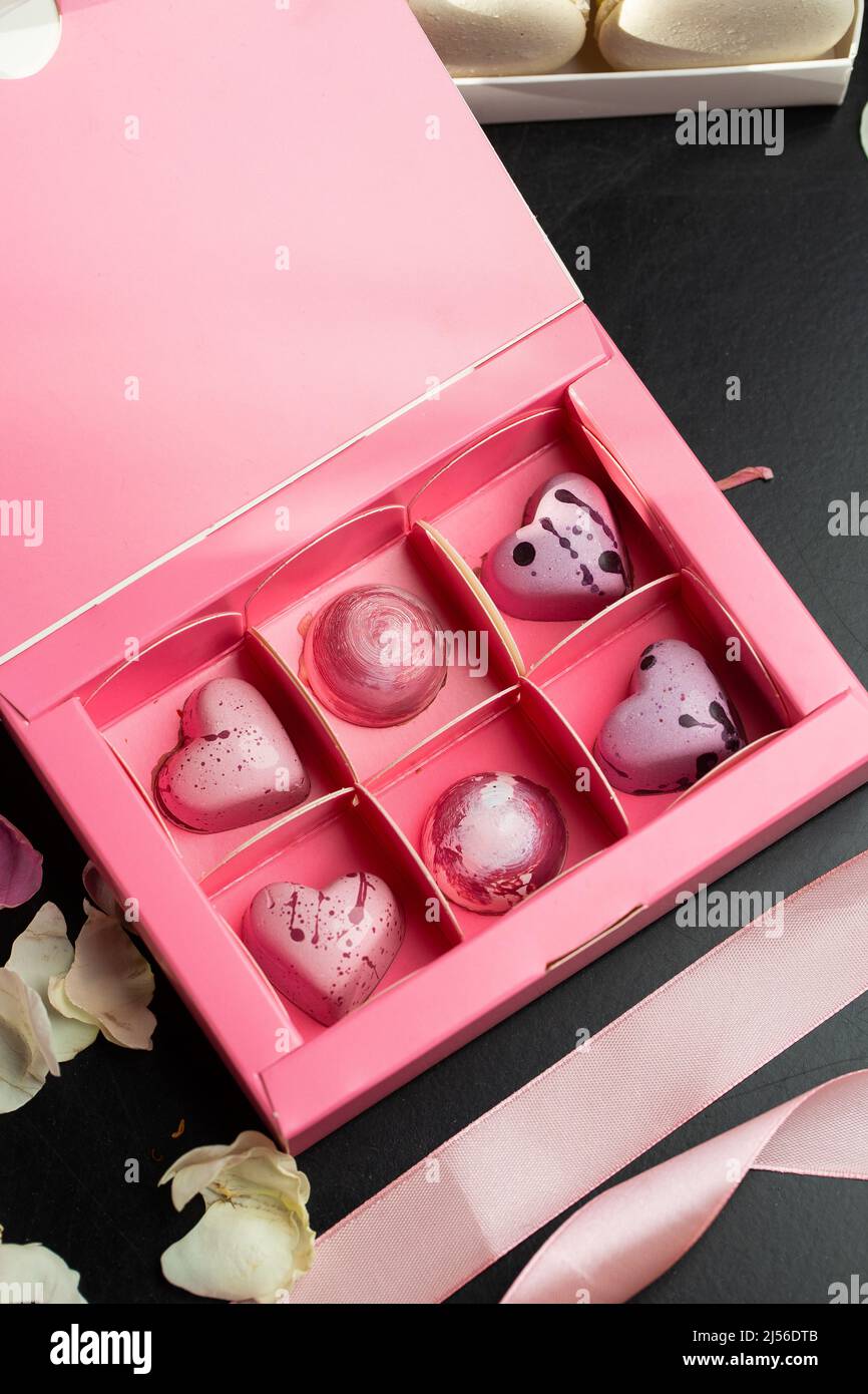 Luxury handmade pink chocolate candy in pink box isolated on dark ...