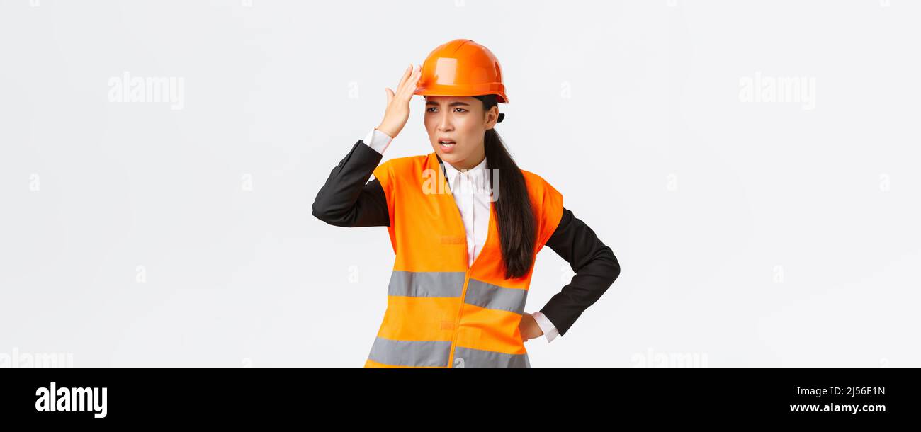 Annoyed and disappointed female asian chief engineer scolding ...