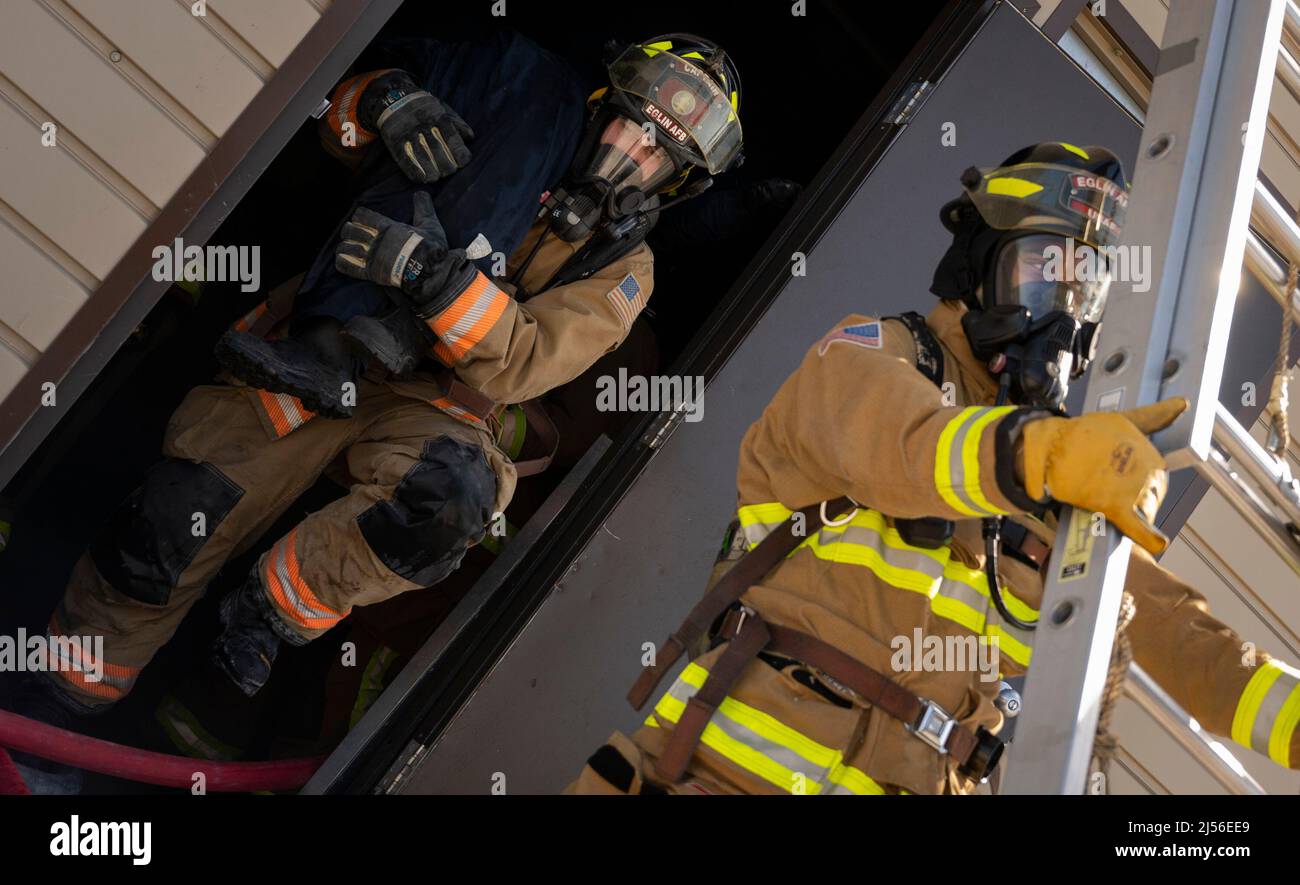 A 96th Civil Engineer Squadron firefighter carries a simulated victim ...