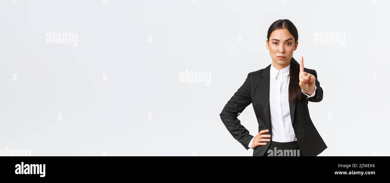 Serious angry asian businesswoman making restriction, give warning sign ...