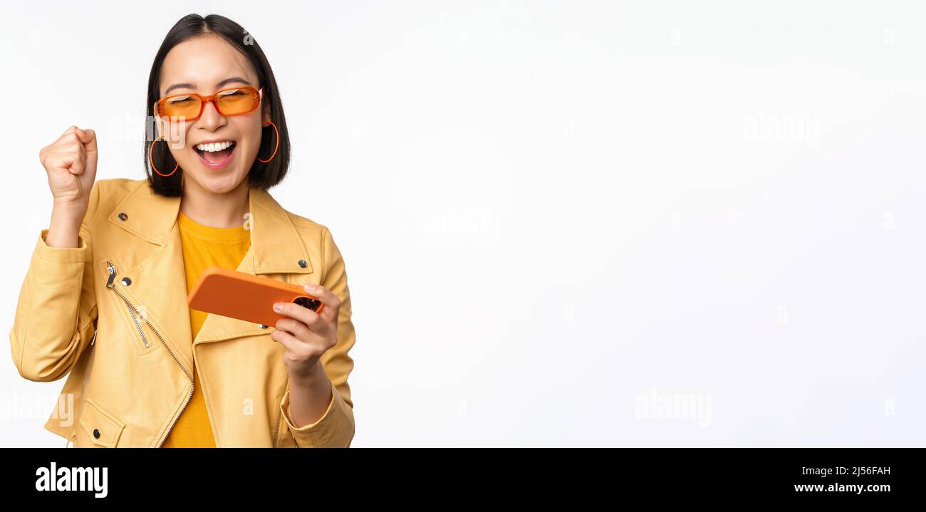 Image of stylish korean girl dancing with smartphone, laughing happy ...