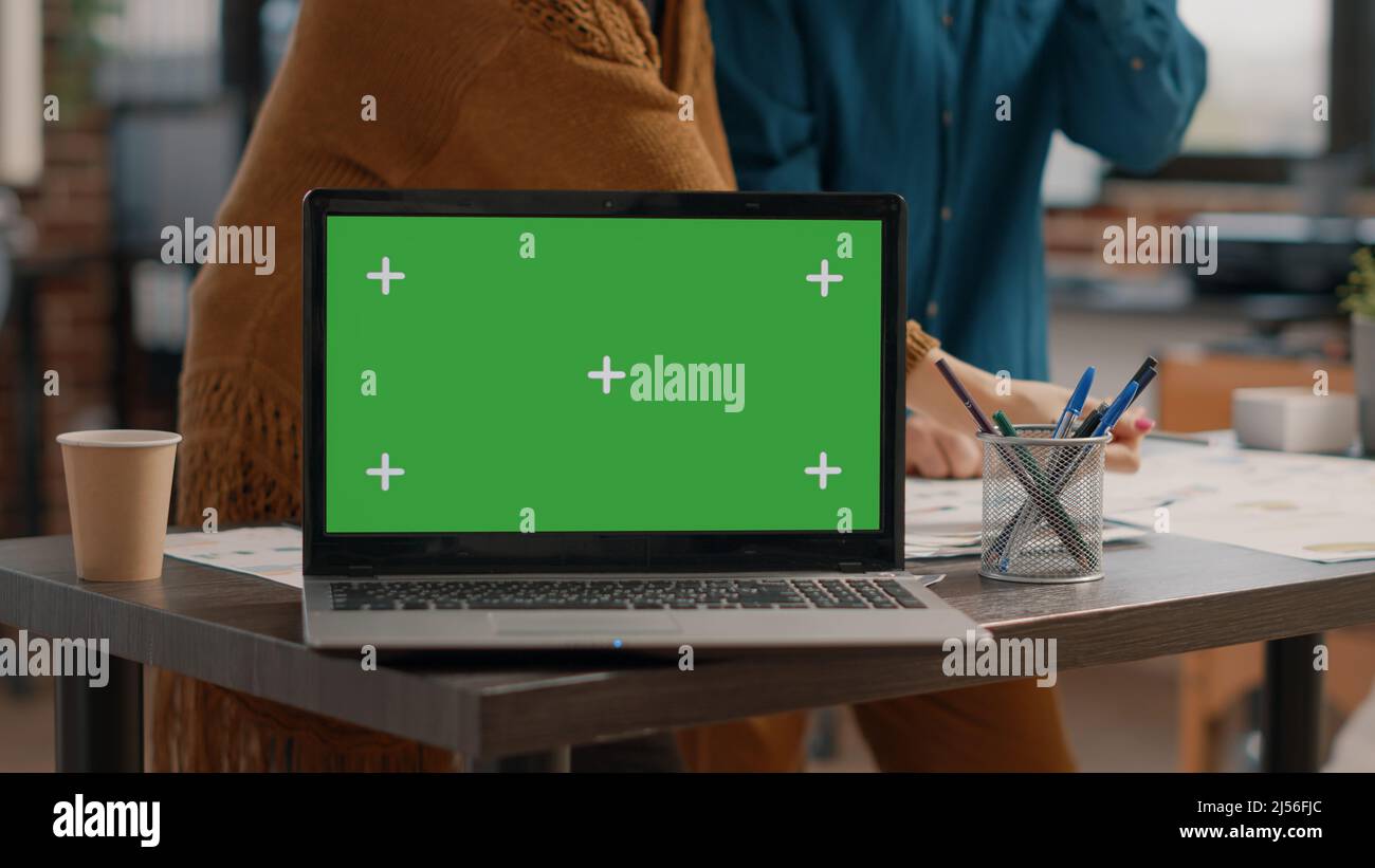 Close up of laptop with horizontal green screen on desk at startup ...