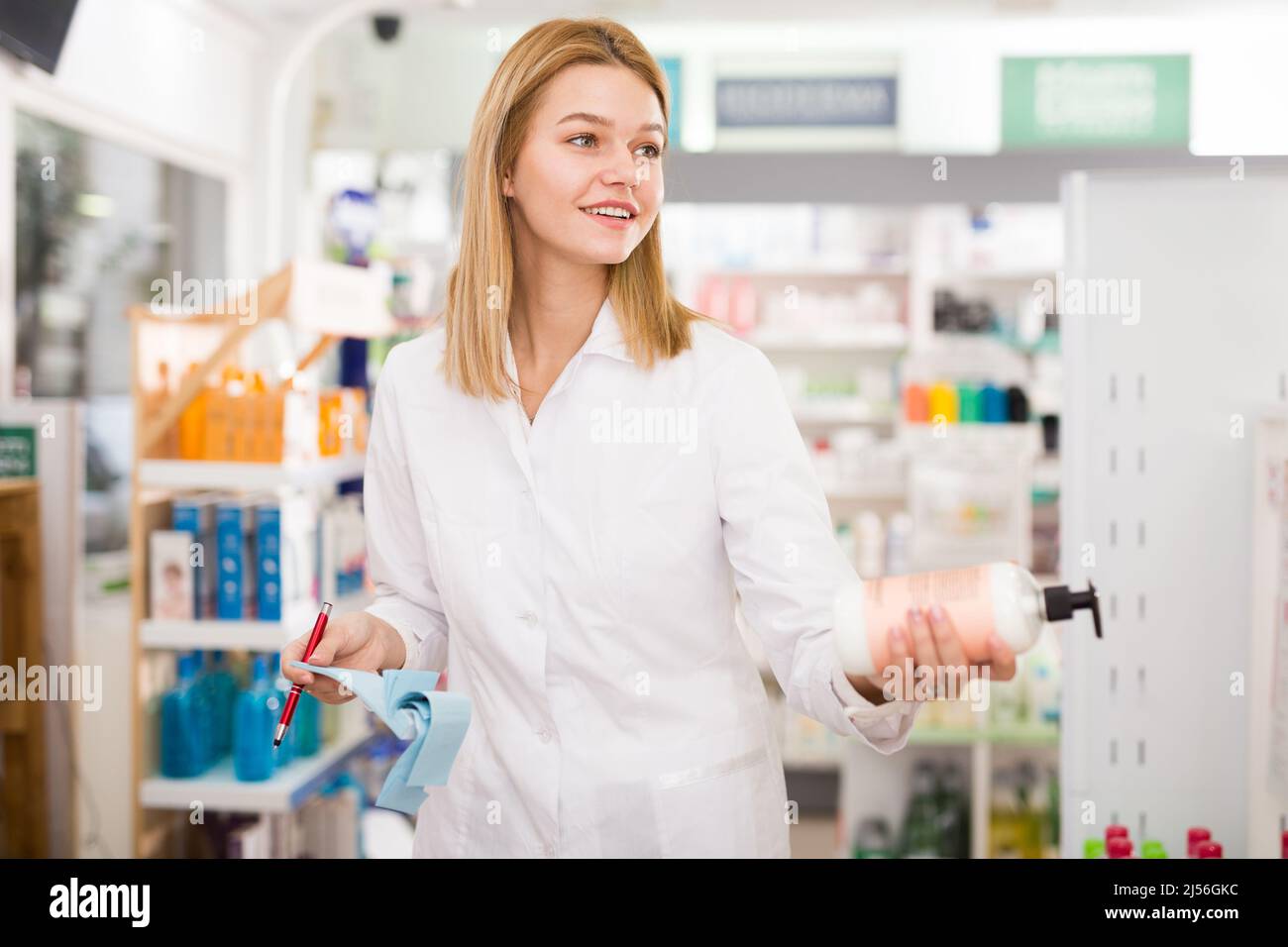 Portrait of friendly laughing pharmacist working in modern farmacy ...