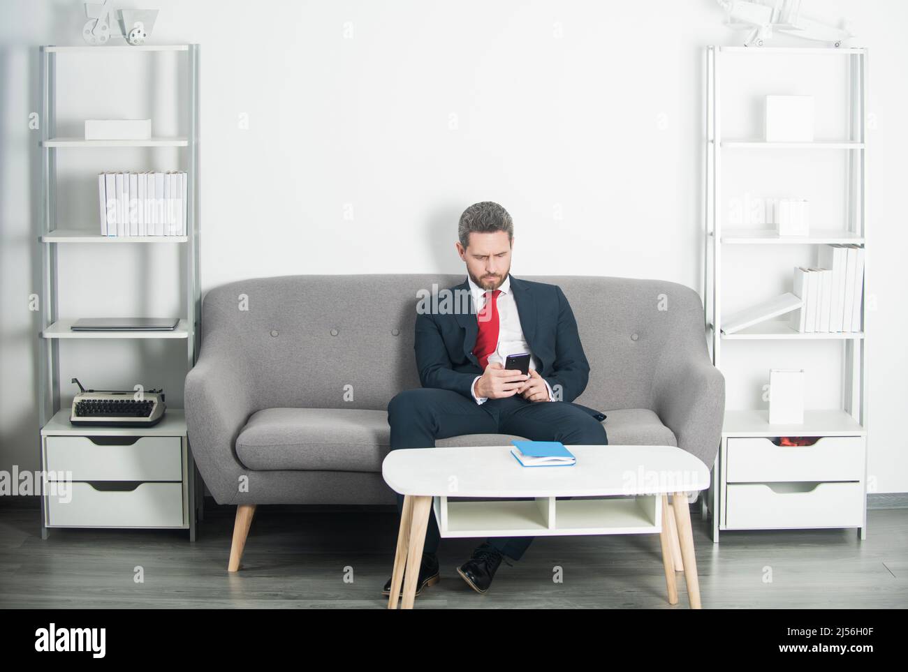 Businessman texting on smartphone sitting hi-res stock photography and ...