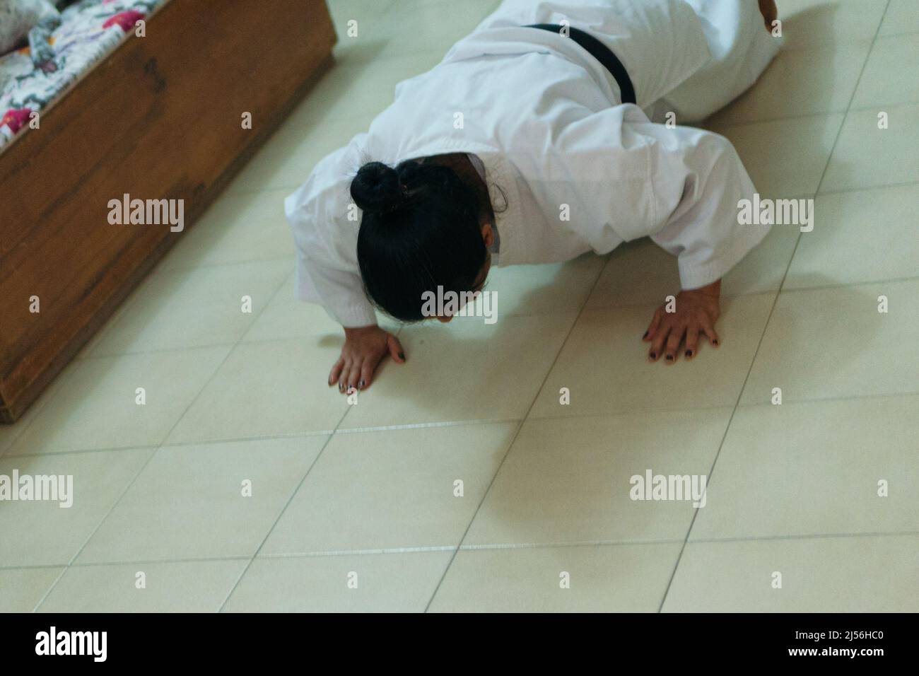 Woman in kimono warming up before karate training. They are doing ...