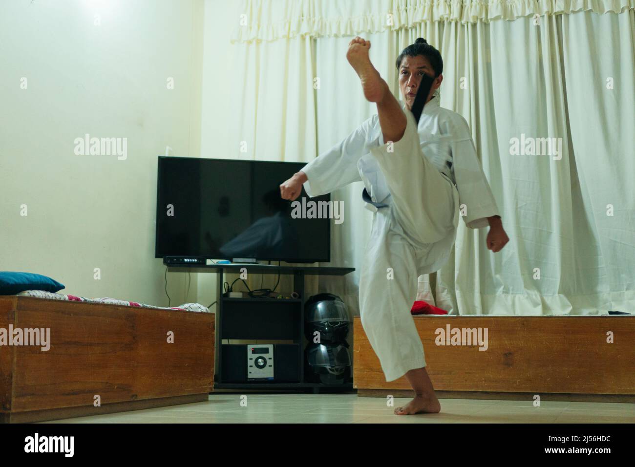 Martial artist executing a crescent kick Stock Photo - Alamy