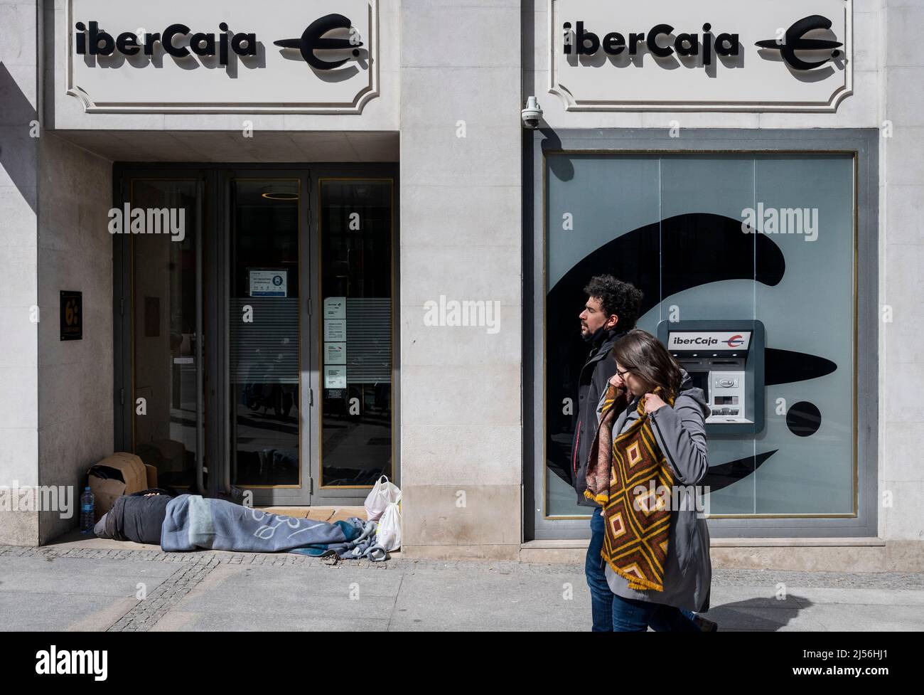 A homeless man is seen sleeping at the entrance of the Spanish ...