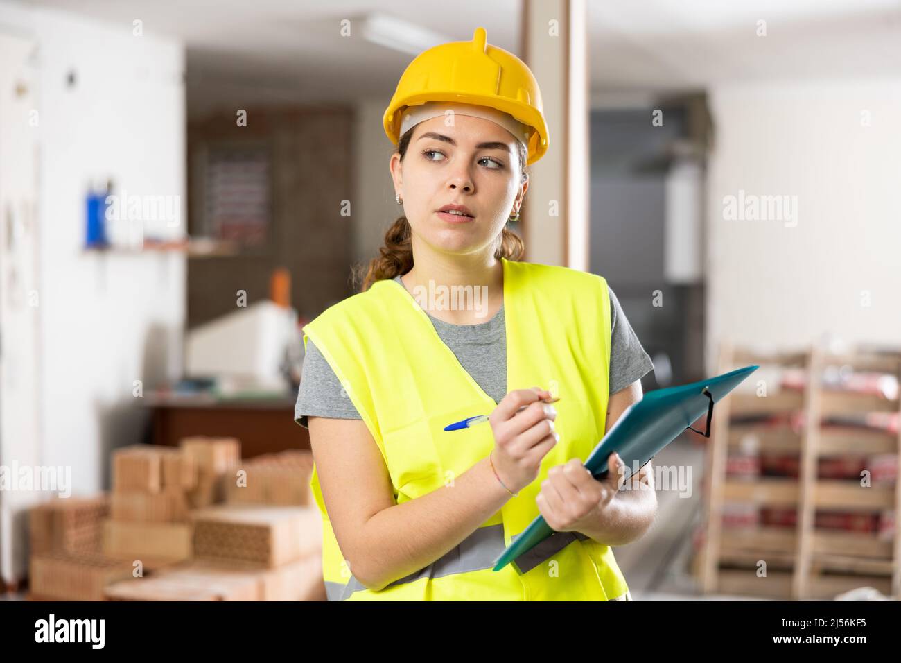 Woman builder checking project documentation Stock Photo - Alamy