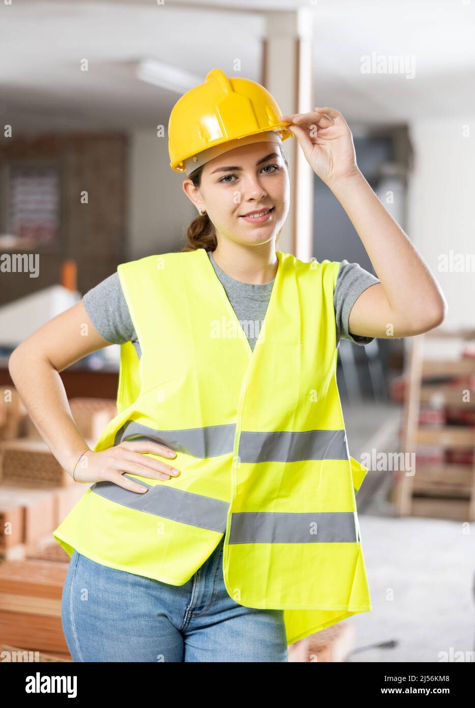 Portrait of positive woman builder standing in construction site Stock ...