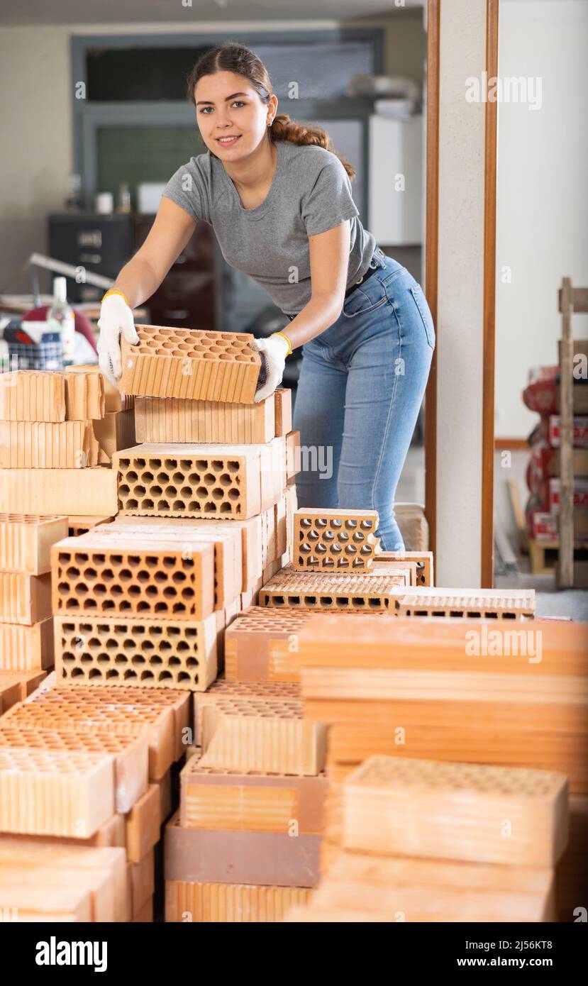 Woman carrying bricks hi-res stock photography and images - Alamy