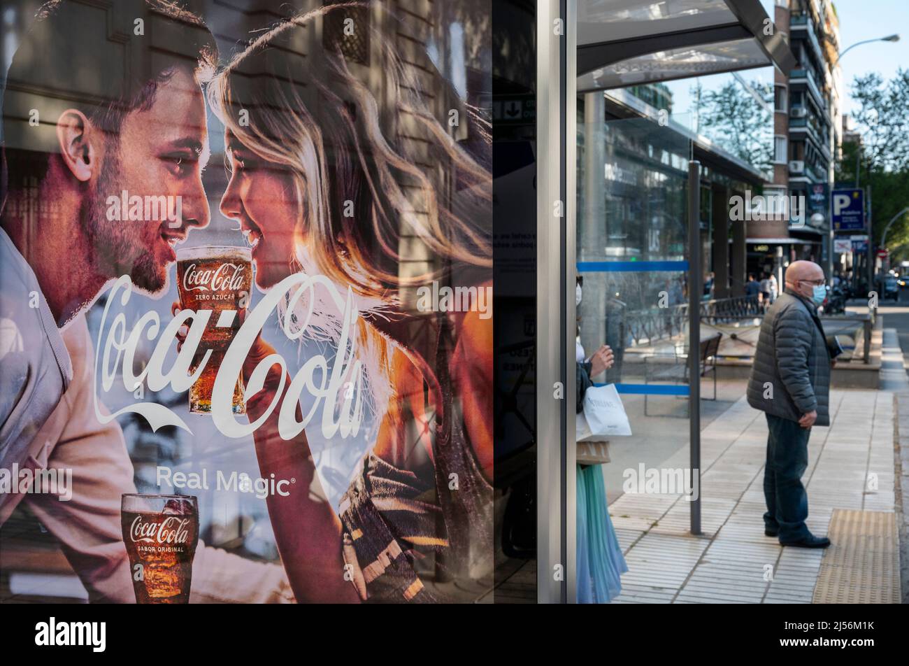 Madrid, Spain. 19th Apr, 2022. Commuters wait at a bus stop displaying ...