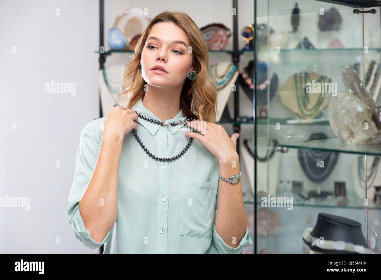 Female client trying on strand of black pearls Stock Photo - Alamy