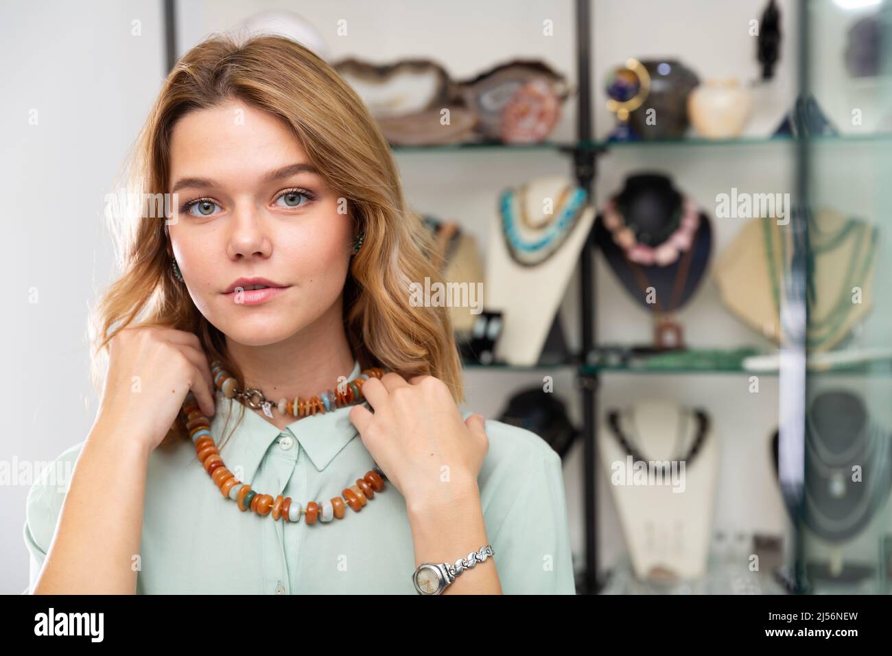 Girl trying on natural stones necklace Stock Photo - Alamy