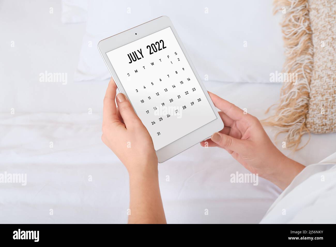 Woman with modern tablet computer using calendar application at home ...
