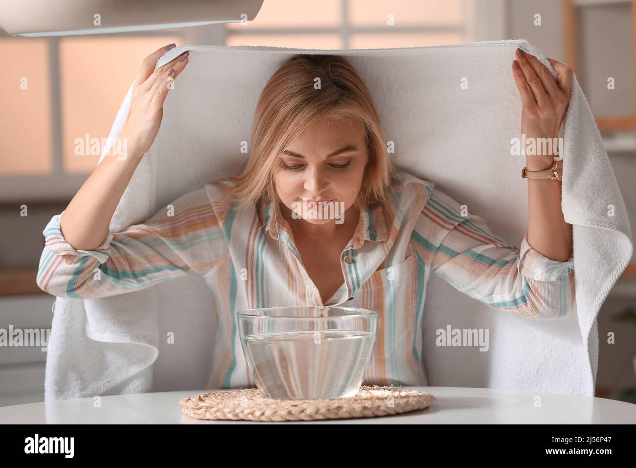 Woman doing steam inhalation at home to soothe and open nasal passages ...