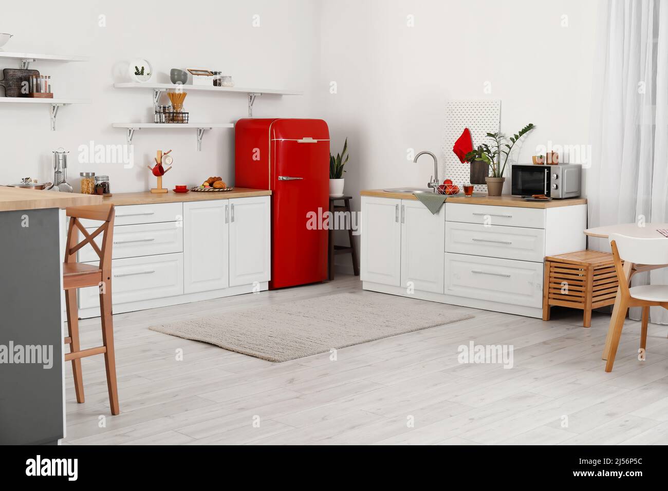 Interior of light kitchen with red fridge, counters and shelves Stock ...