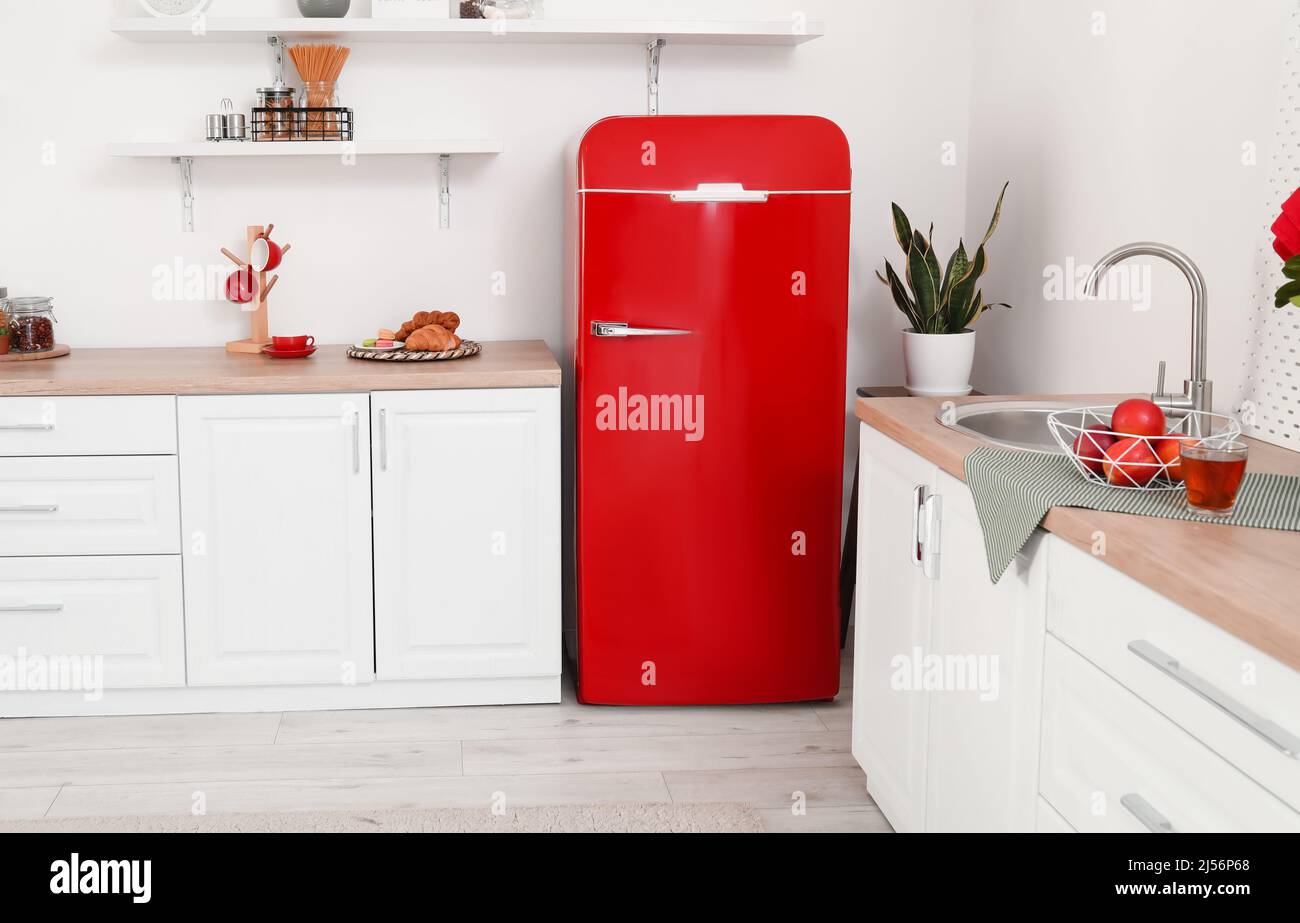 Interior of light kitchen with red fridge, counters and shelves Stock ...