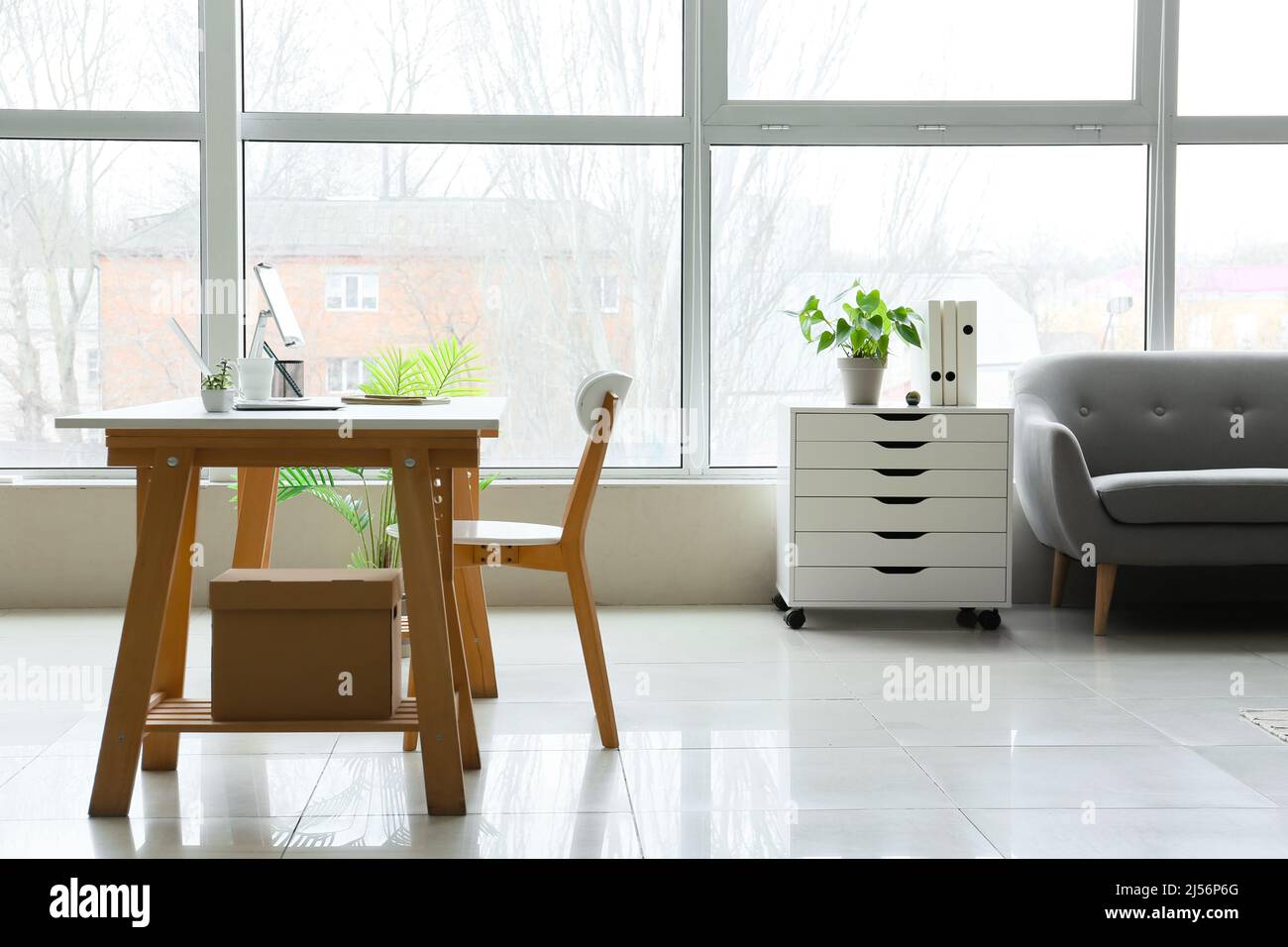 Comfortable workplace in light office with big window Stock Photo - Alamy