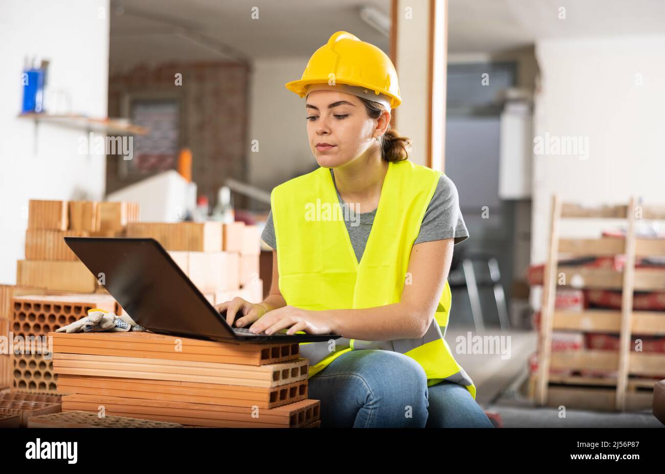 Female civil engineer using laptop at construction site indoors Stock ...