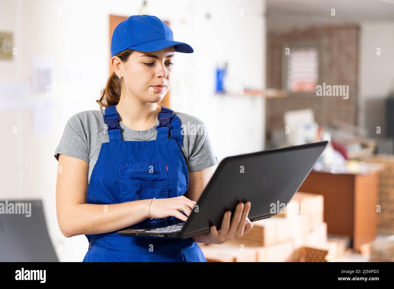 Female foreman working with laptop in building under construction Stock ...