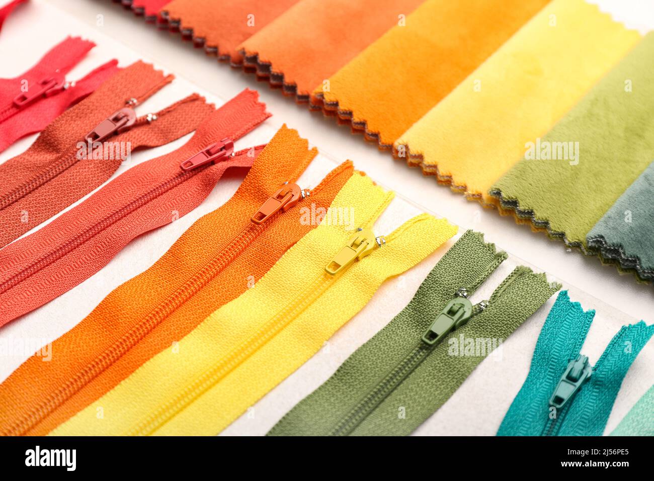 Stylish different zippers and fabric samples on light background Stock ...