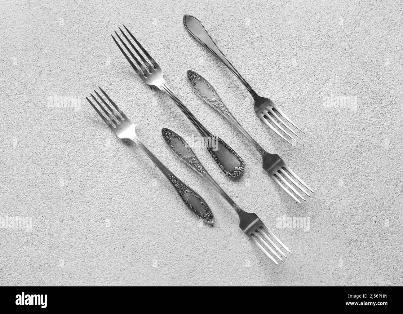 Silver forks on light background Stock Photo - Alamy