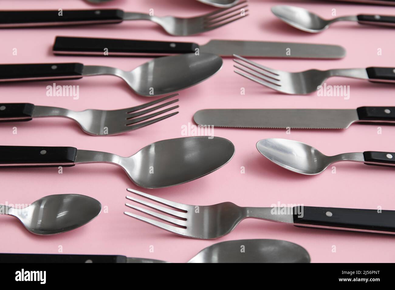 Many different cutlery on pink background Stock Photo - Alamy