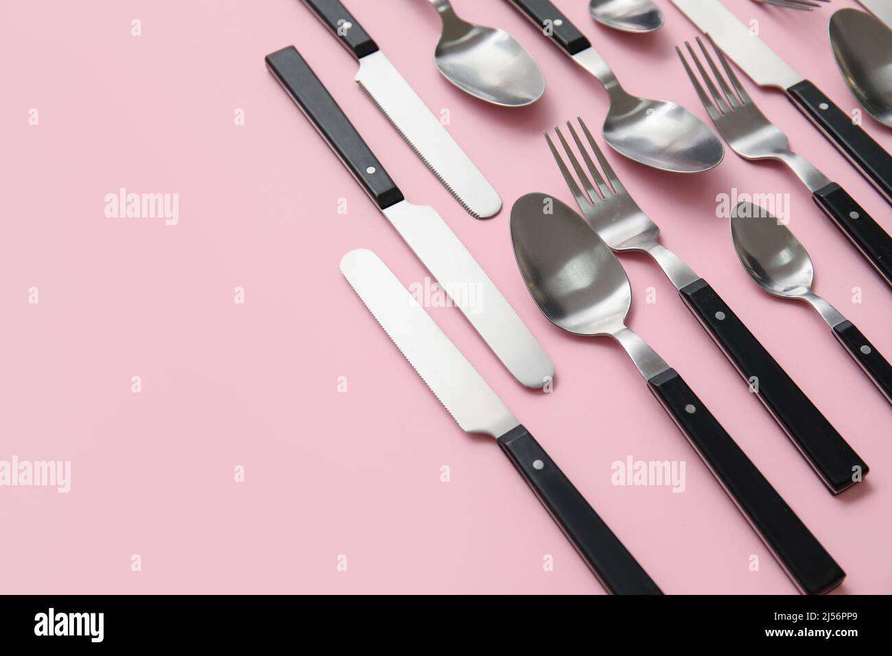 Many different cutlery on pink background Stock Photo - Alamy