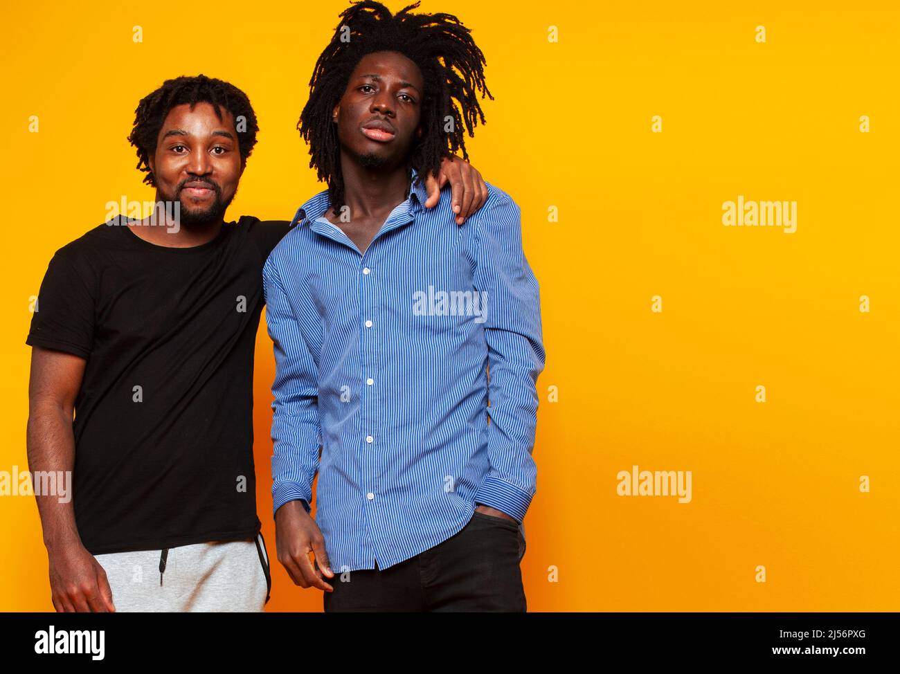 two african american guys posing cheerful together on yellow background ...