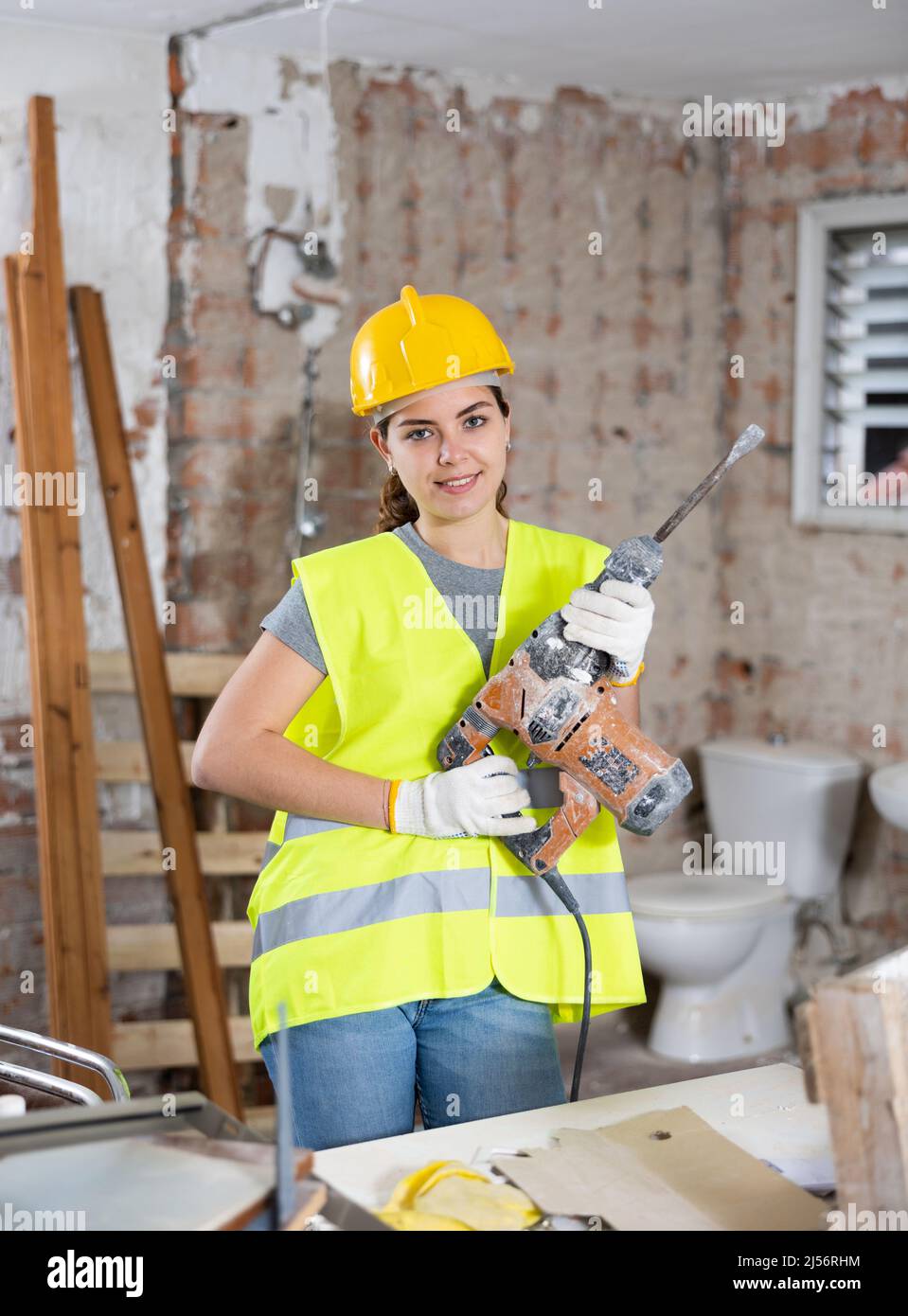 Young woman holding hammer drill hi-res stock photography and images ...