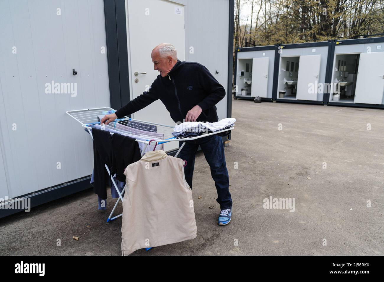 A man hangs clothes to dry at the settlement for displaced people ...