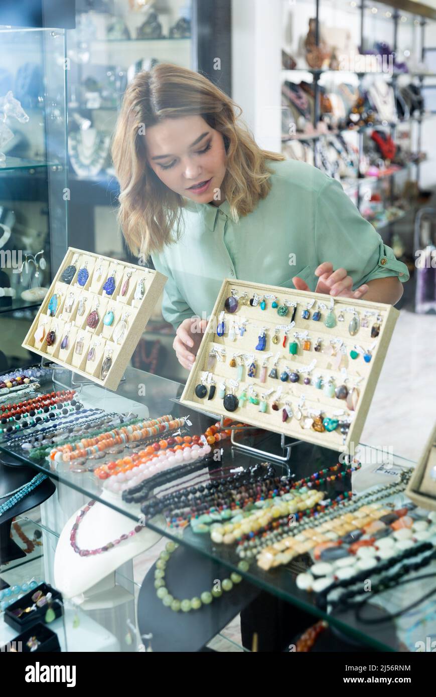 Saleswoman working behind window of jewelry shop Stock Photo - Alamy