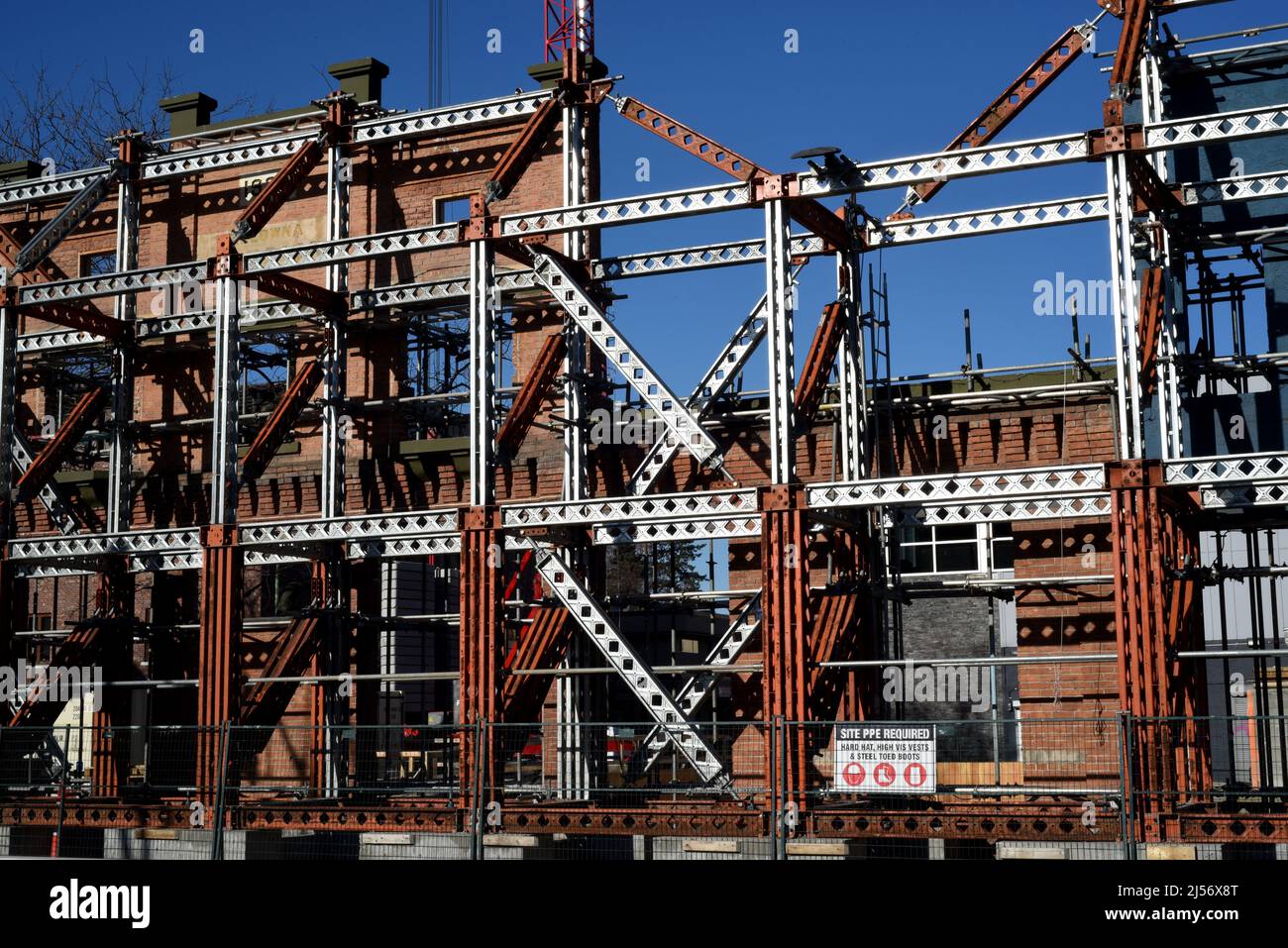 Metal supports for an old brick architectural facade hold it in place ...
