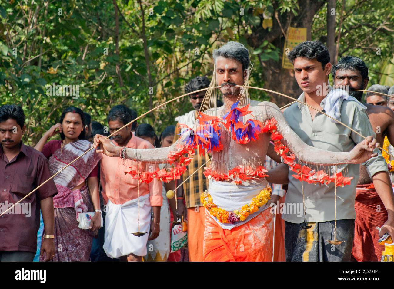 Man piercing spikes through cheeks discharging vow in Thaipusam ...