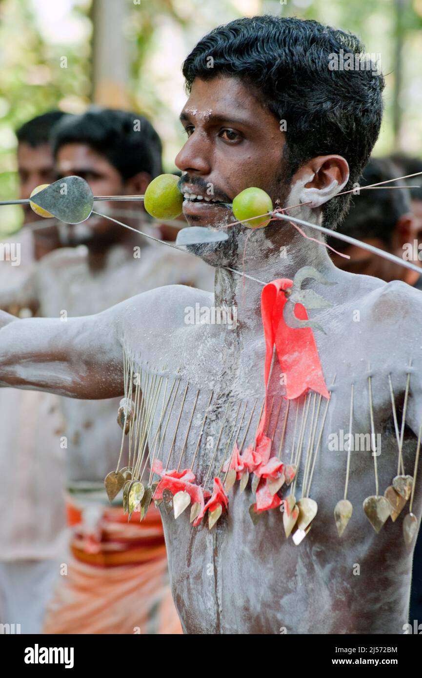 Man piercing spikes through cheeks discharging vow in Thaipusam ...